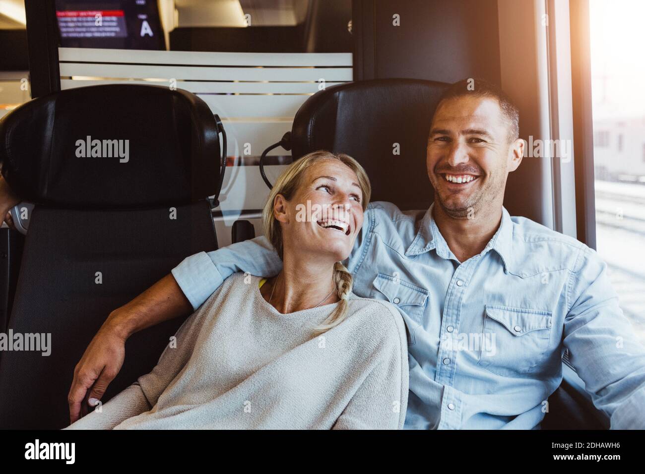 Happy couple enjoying journey in train Stock Photo - Alamy