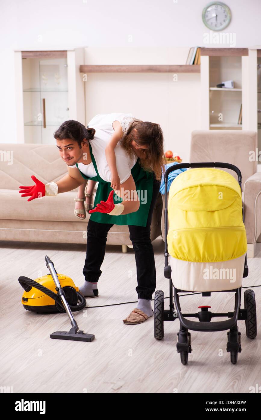 Young male contractor cleaning the house with his small daughter Stock ...
