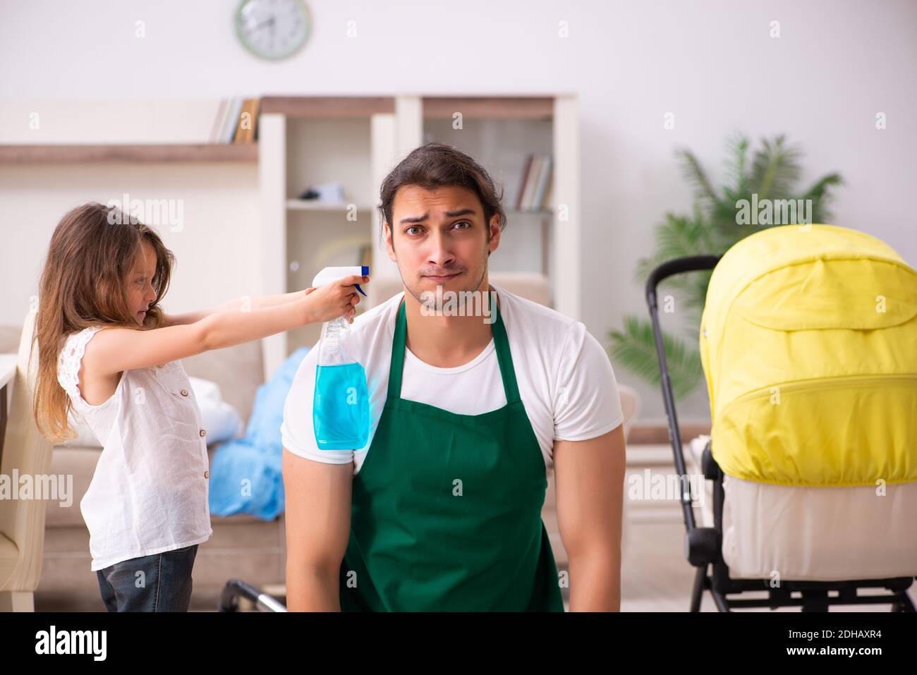 Young male contractor cleaning the house with his small daughter Stock ...