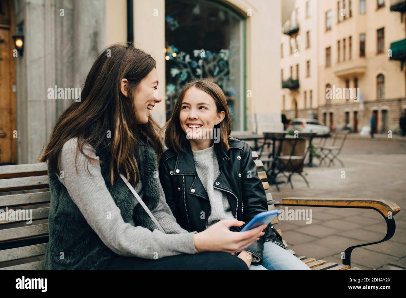 Two girls talking on bench hi-res stock photography and images - Alamy