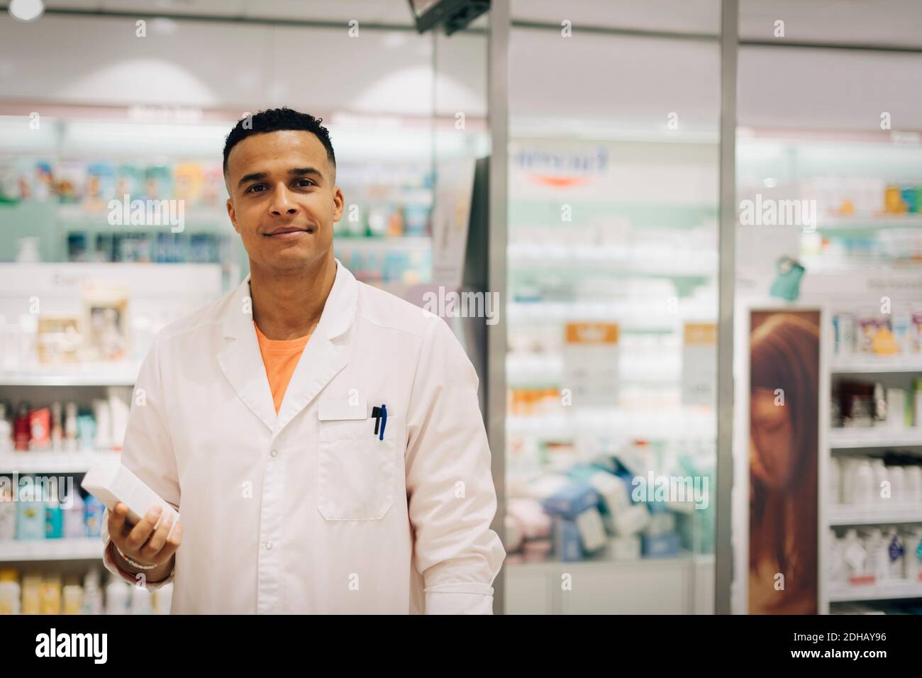 Portrait of confident owner wearing lab coat standing with medicine in ...