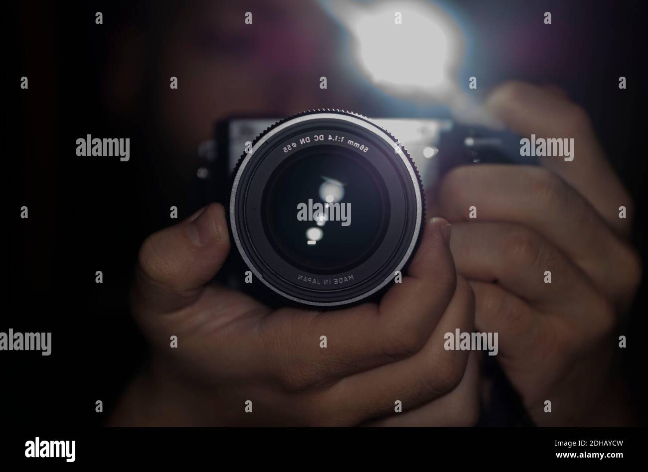 Self-portrait with the camera lens in the foreground in front of the ...