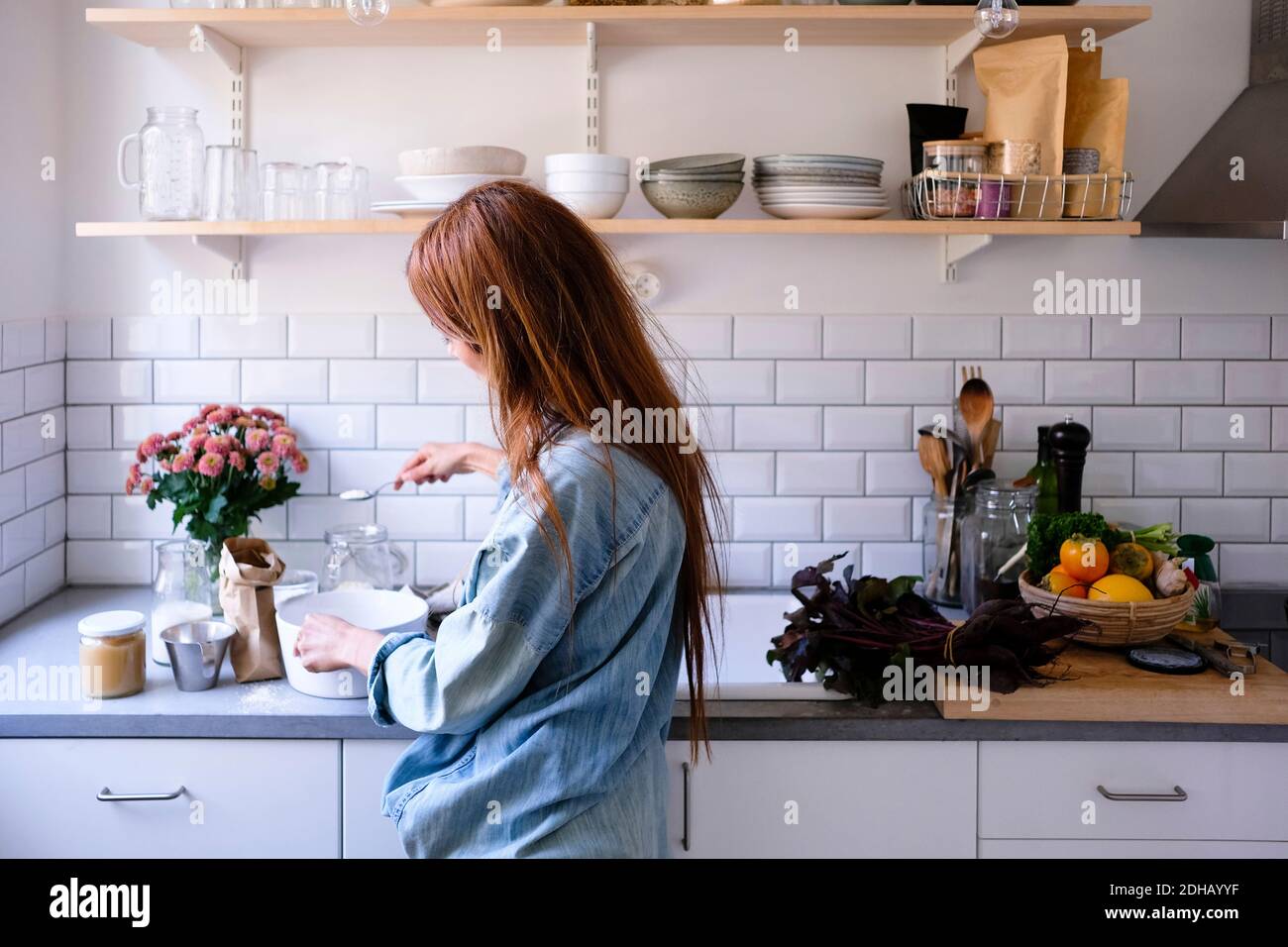 Woman cooking food by kitchen counter at home Stock Photo - Alamy