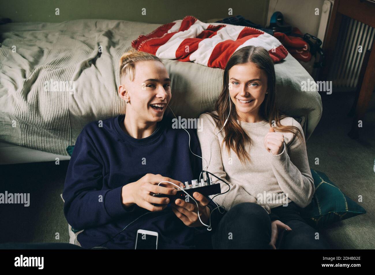Portrait of teenage boy and girl using sound mixer while listening ...