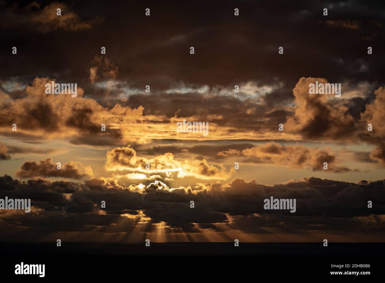 Aerial view of evening sun hiding behind group of dark clouds Stock ...