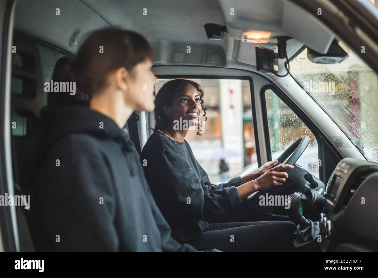 Female mover looking in rear-view mirror while driving truck Stock ...