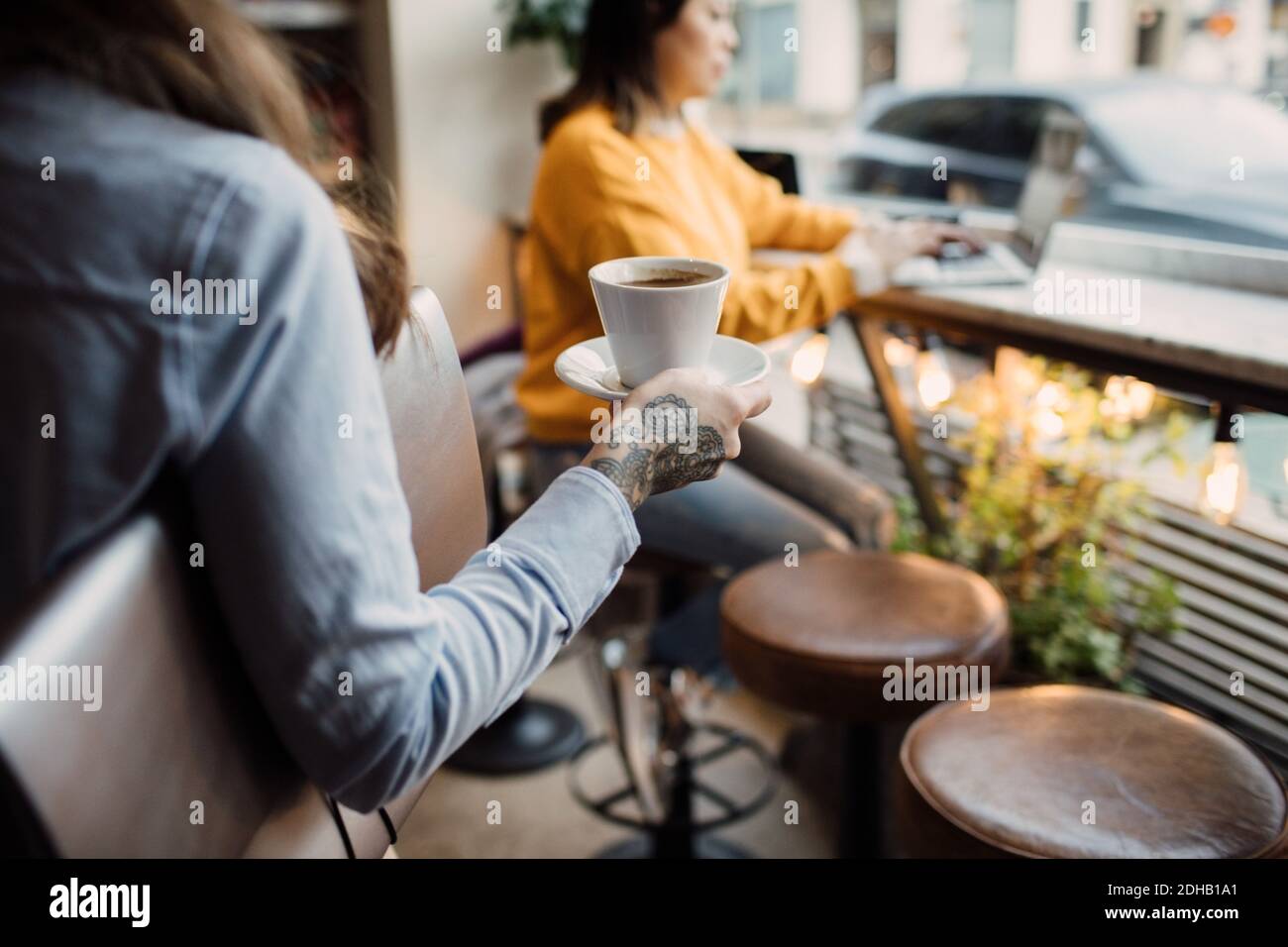 Rear view of woman holding coffee cup walking in cafe Stock Photo - Alamy