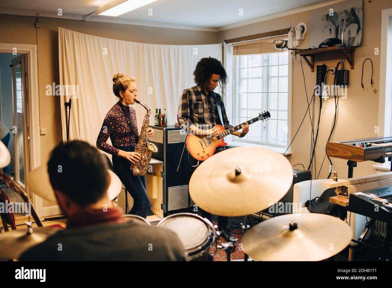 Friends playing musical instruments at studio Stock Photo - Alamy