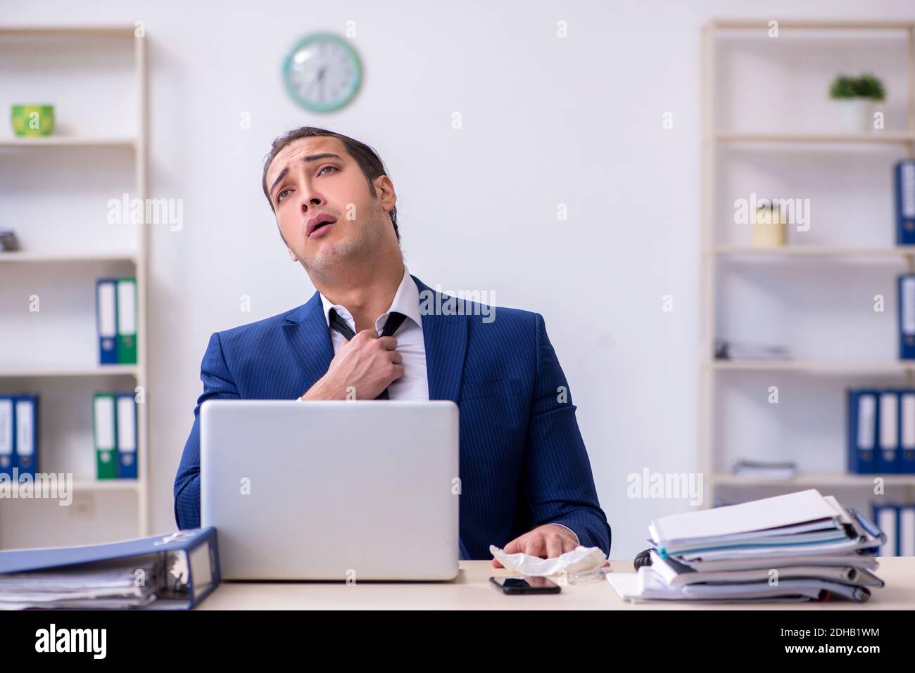 Sick male employee suffering at workplace Stock Photo - Alamy