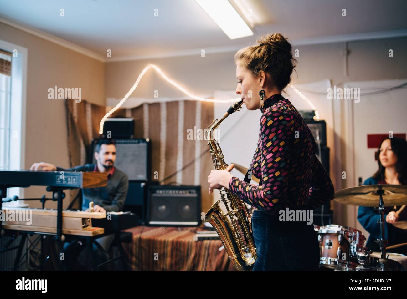 Friends playing various instruments while practicing at recording ...