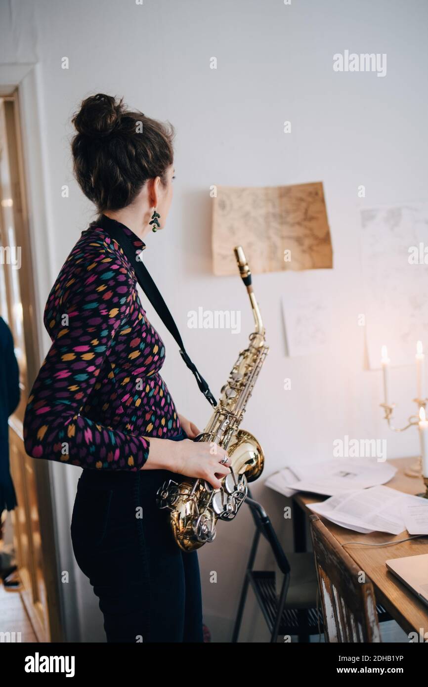 Side view of woman playing saxophone while practicing at studio Stock ...