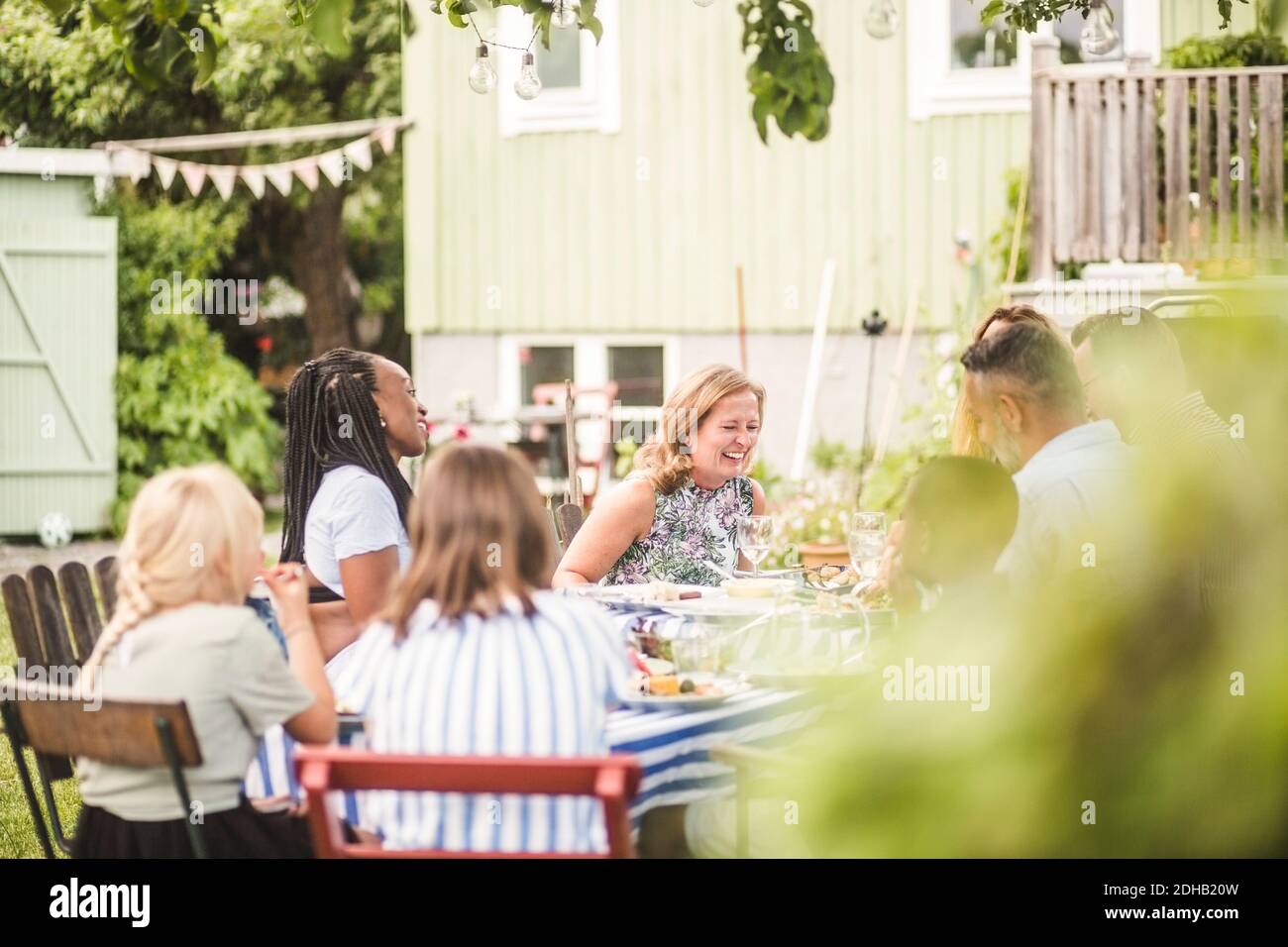 Happy friends and family having food together at backyard party Stock ...