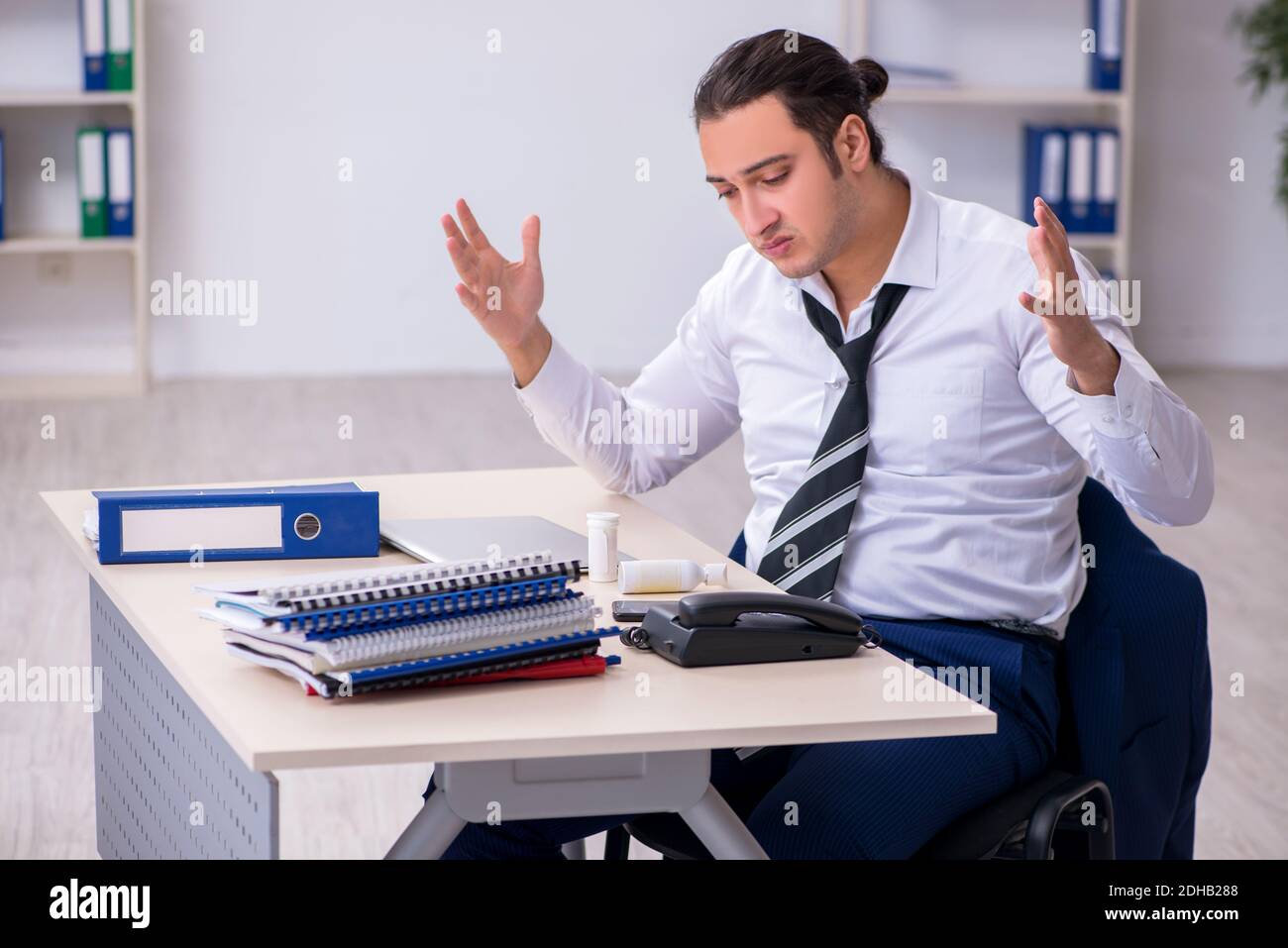 Sick male employee suffering at workplace Stock Photo - Alamy