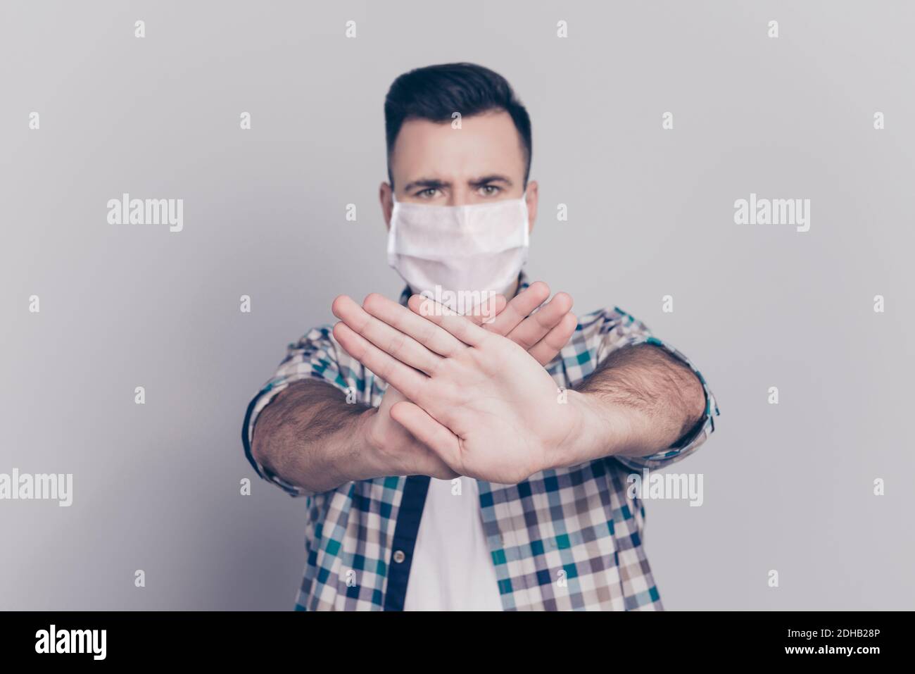 Close-up portrait of nice strict guy wearing safety mask showing stop ...