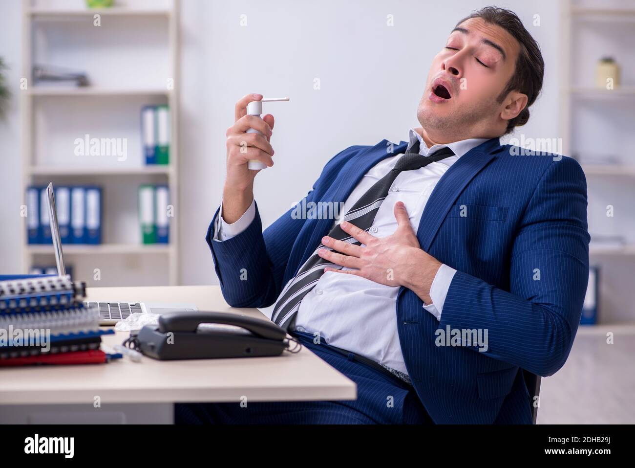 Sick male employee suffering at workplace Stock Photo - Alamy