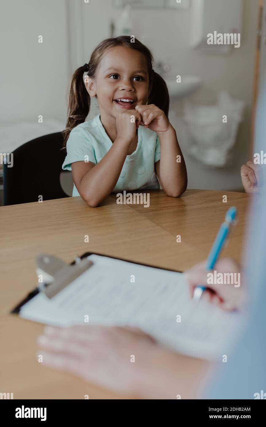 Smiling girl talking with doctor during medical exam in hospital Stock ...
