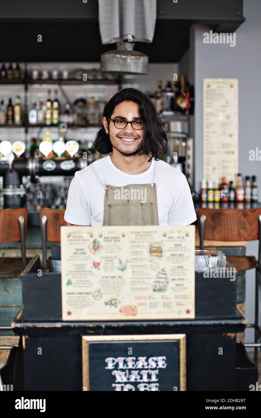 Portrait of smiling owner standing at lectern in restaurant Stock Photo ...