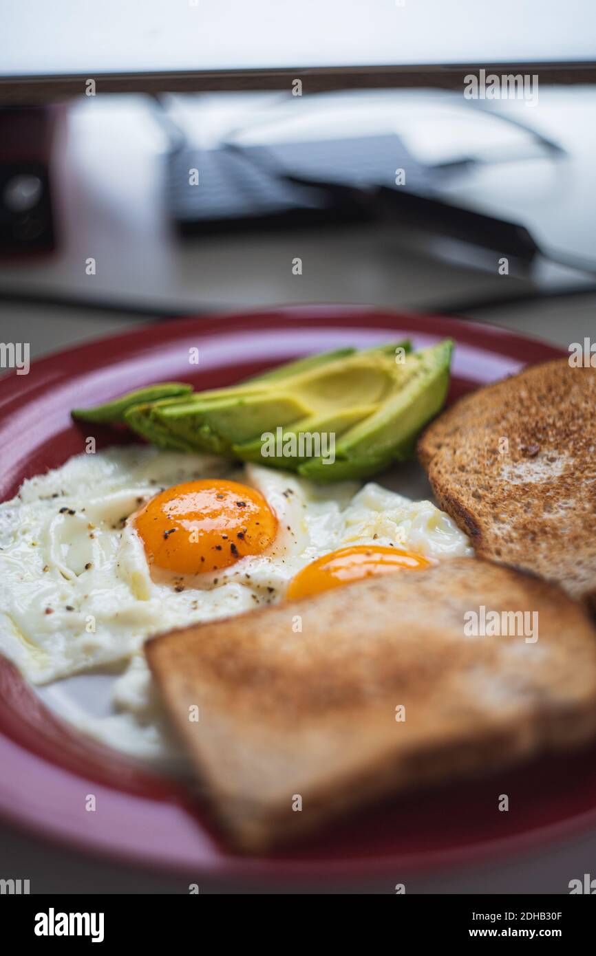 A vertical closeup shot of a breakfast plate with a toast, an omelet ...
