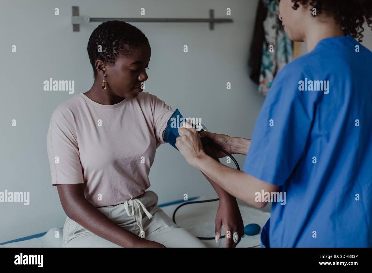 Nurse checking blood pressure of female patient in clinic Stock Photo ...