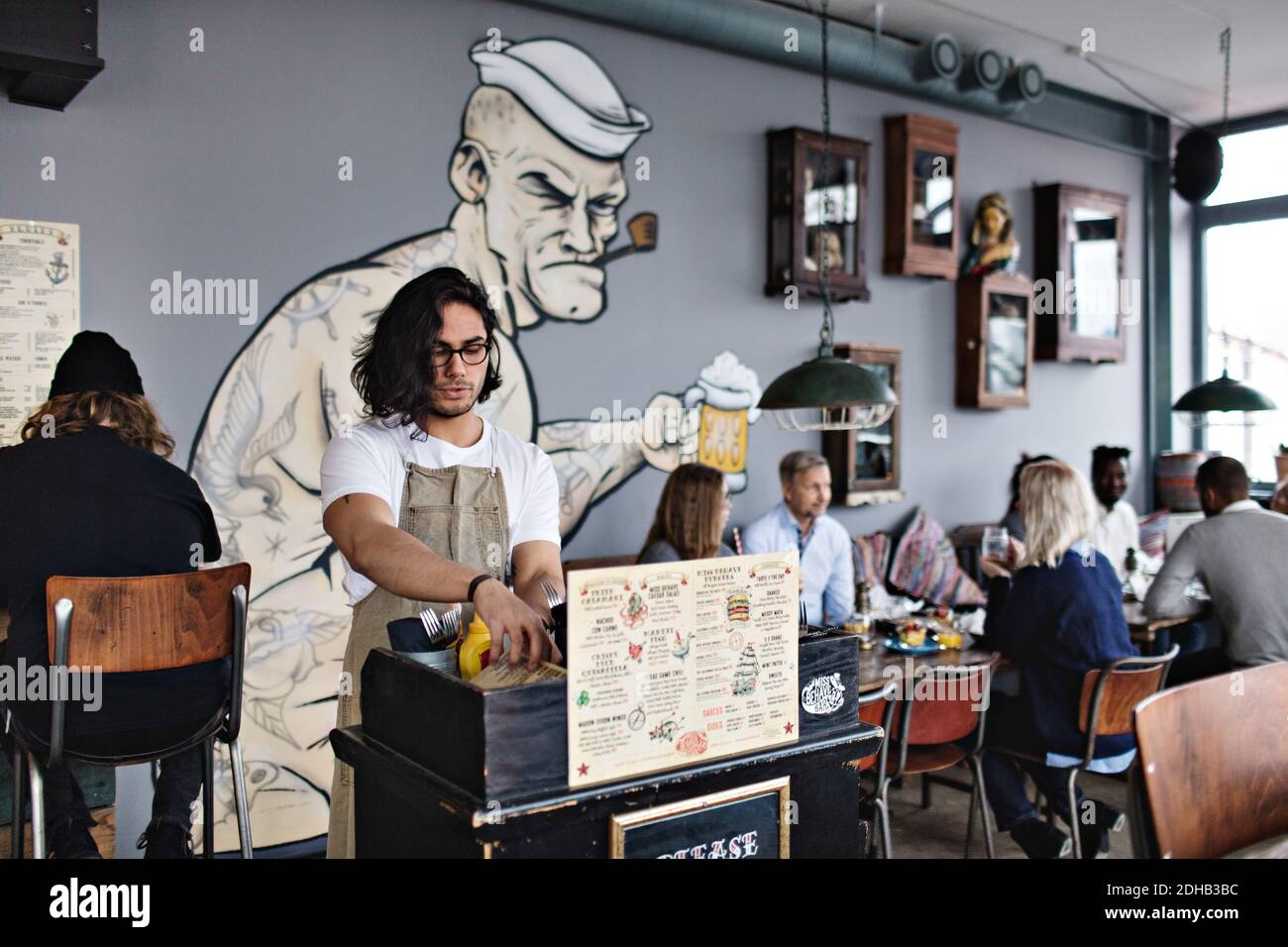 Young owner standing at lectern while customers having brunch in ...
