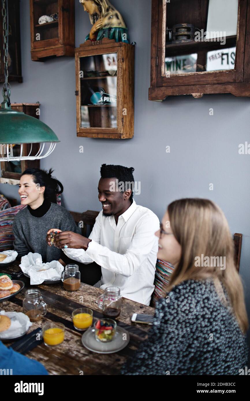 Happy multi-ethnic friends enjoying brunch at table in restaurant Stock ...