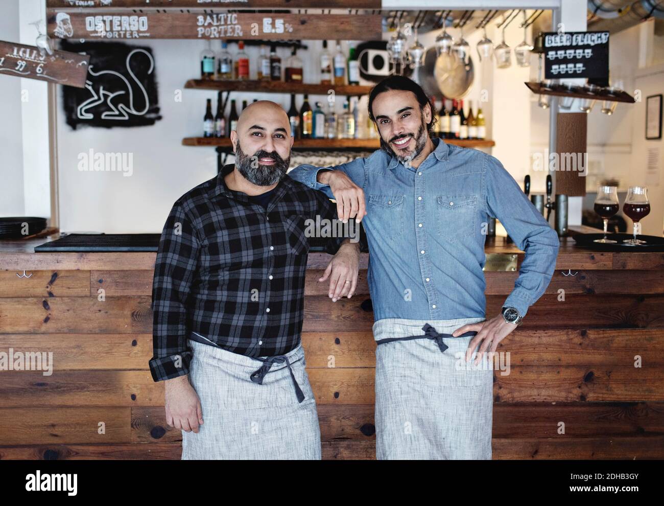 Portrait of male partners standing at bar counter Stock Photo - Alamy