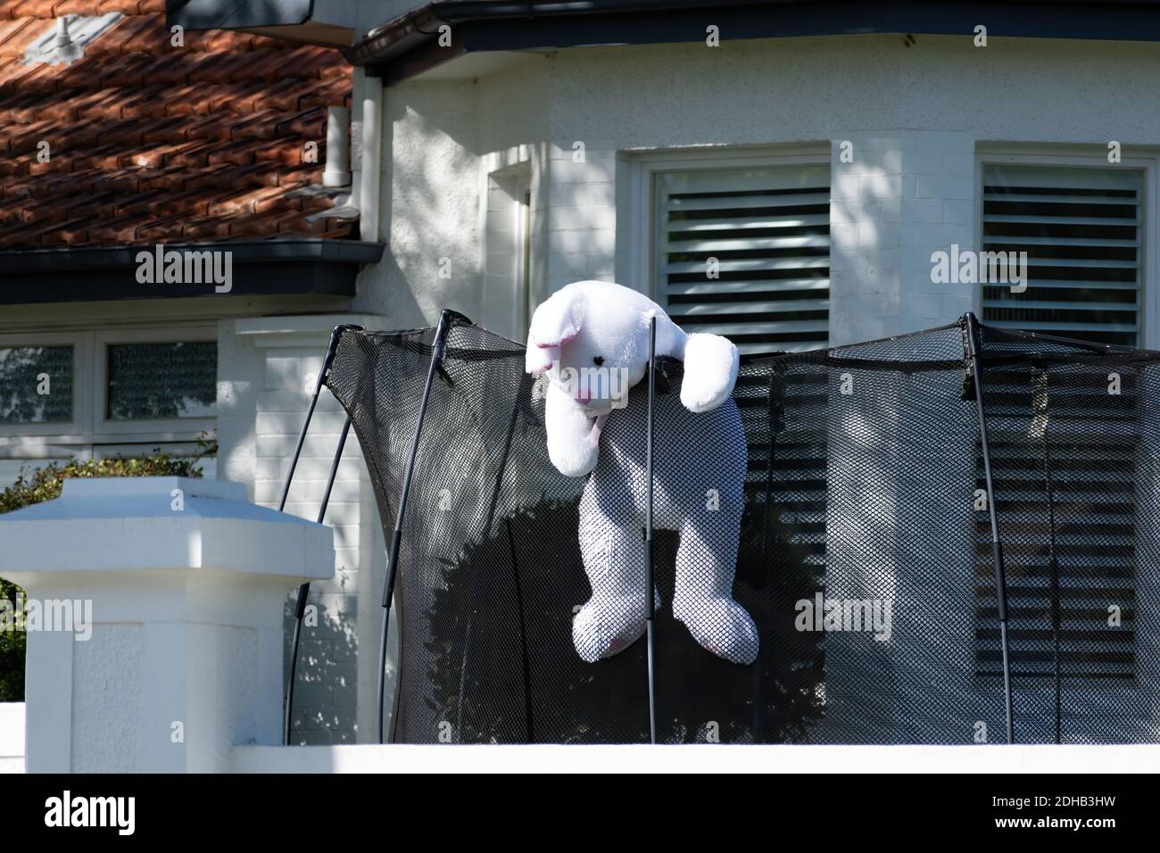 View of white Easter bunny soft toy hanging on outdoor trampoline ...