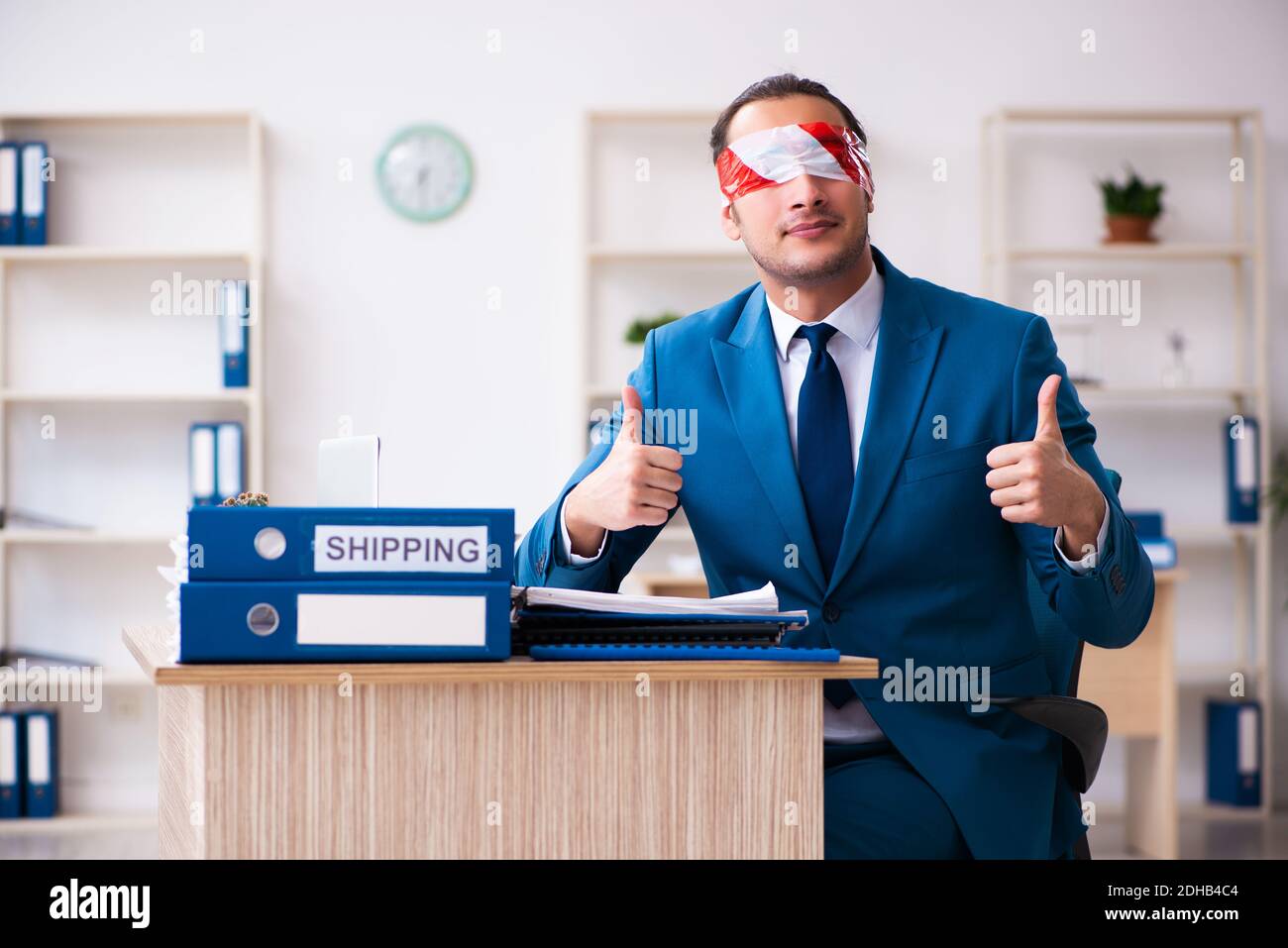 Blindfolded male employee working in the office Stock Photo - Alamy