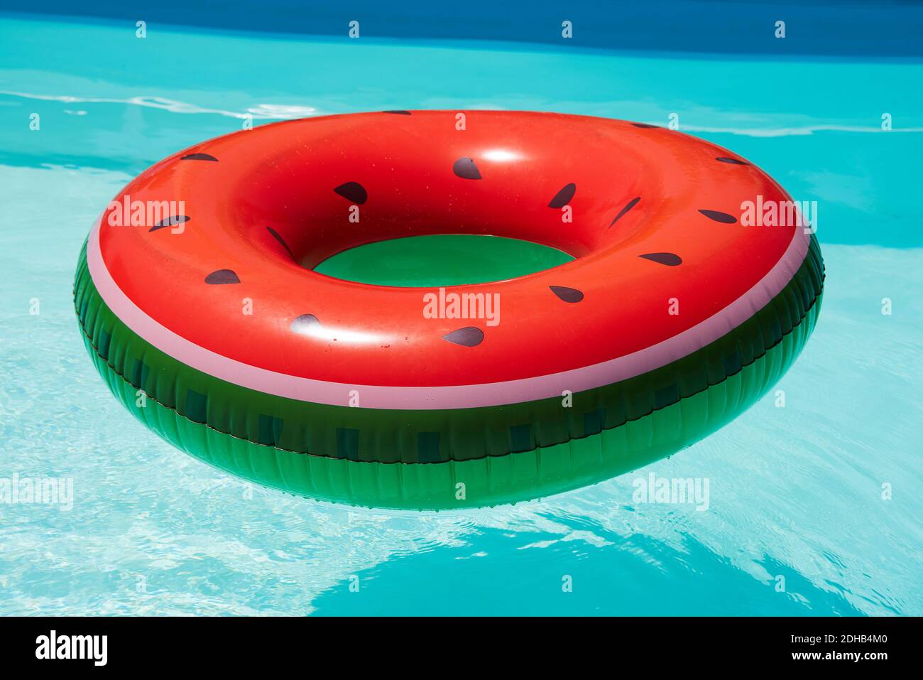 Inflatable watermelon patterned ring, floating in a swimming pool in ...