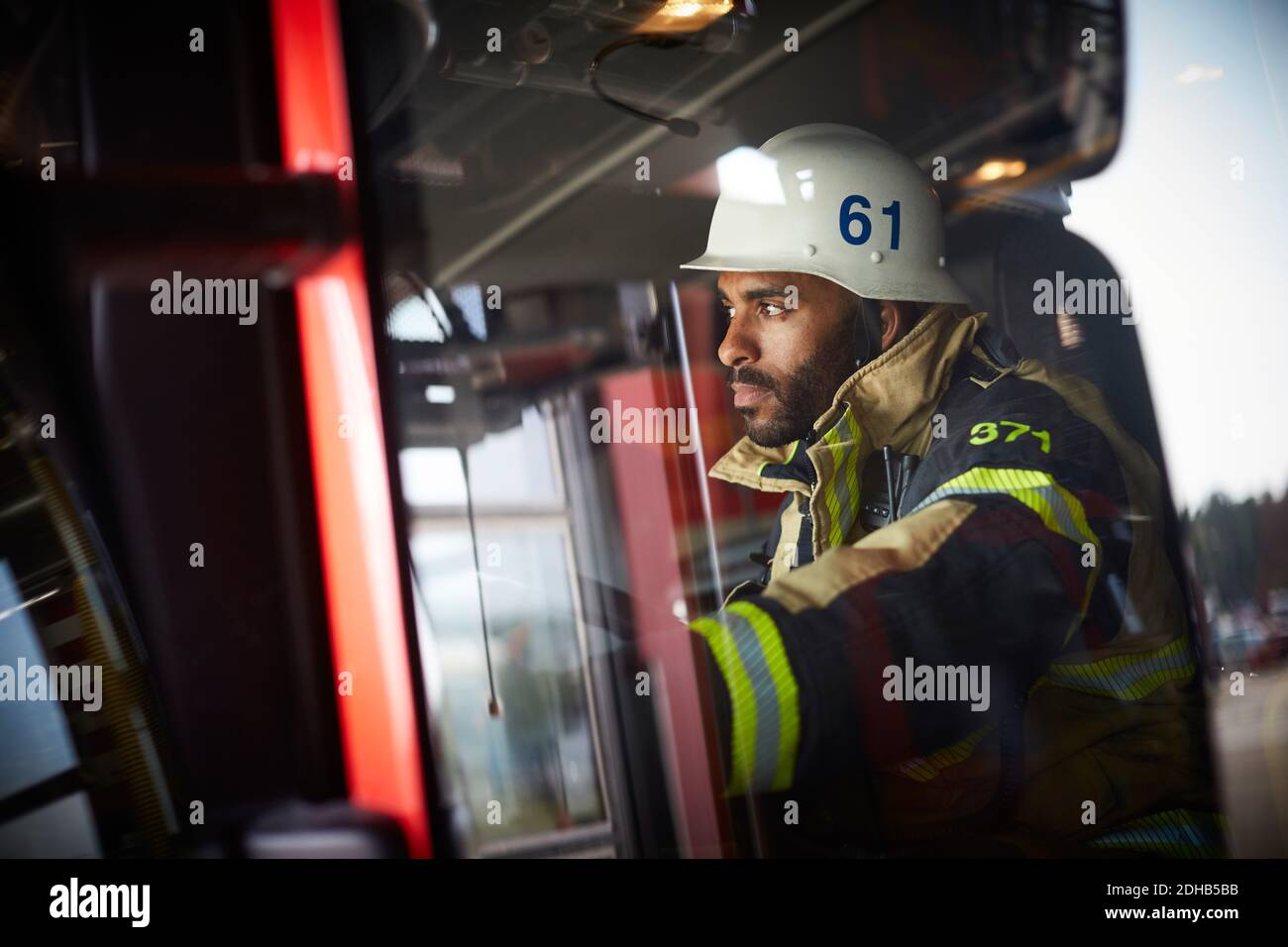 Confident firefighter looking away while sitting in fire engine Stock ...