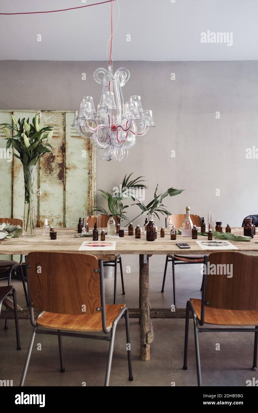 Perfume bottles on table amidst chairs at workshop Stock Photo - Alamy