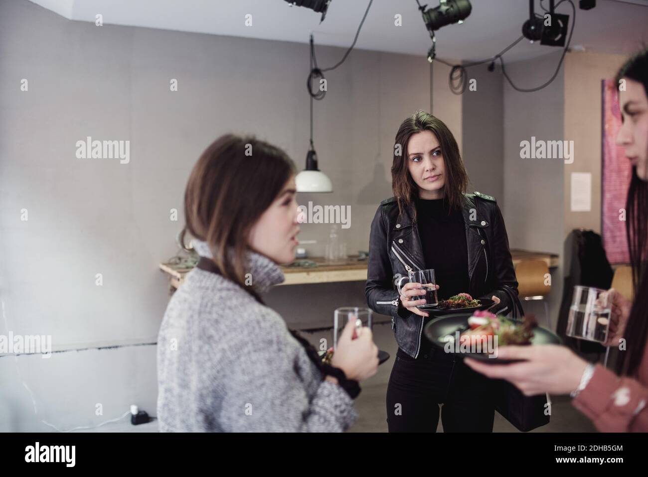Females standing with lunch in workshop Stock Photo - Alamy