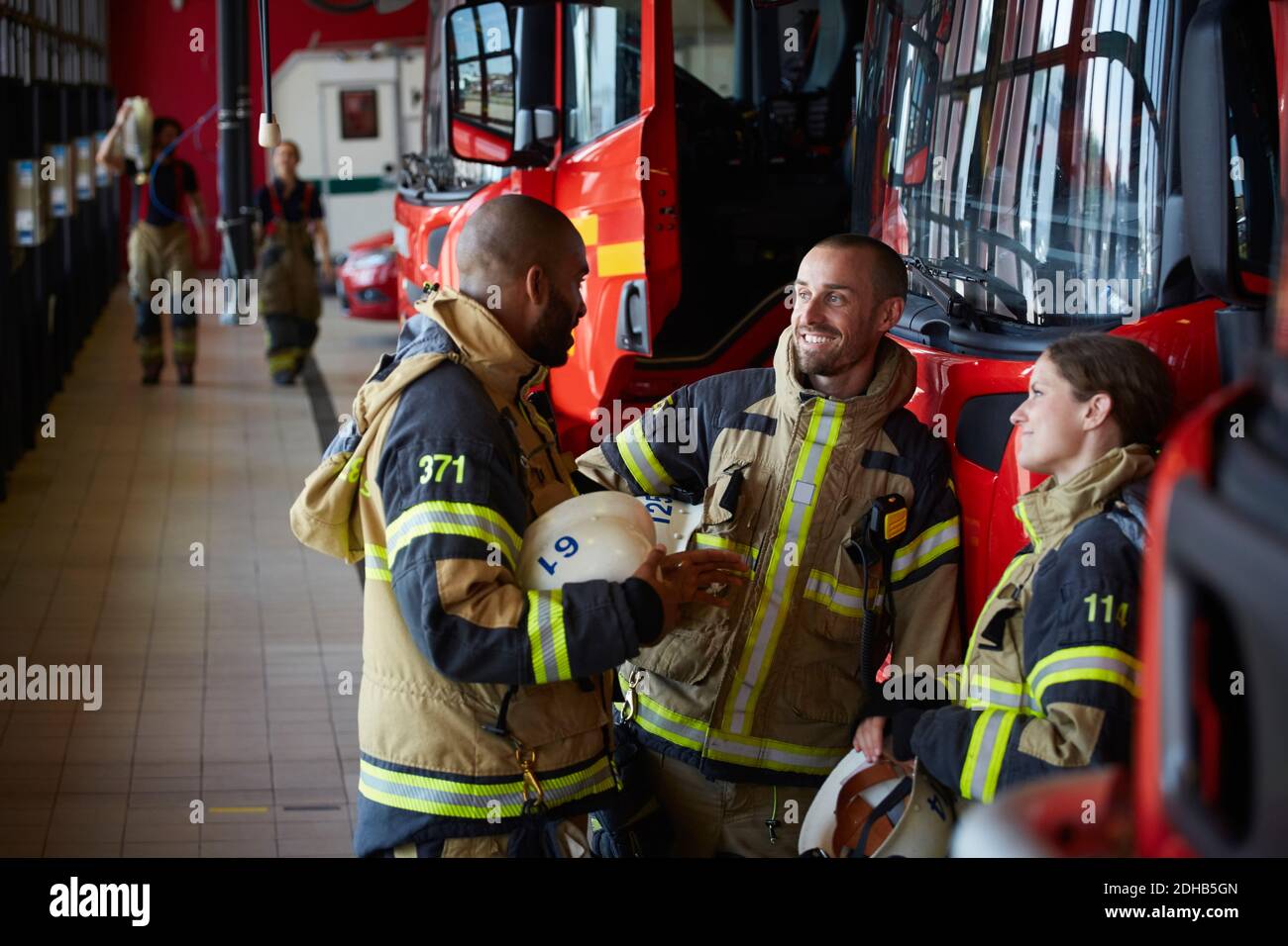 Firefighters in uniform talking while standing at fire station Stock ...