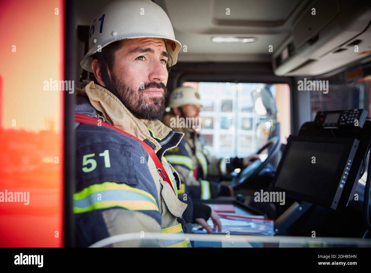 Firefighter looking through window while sitting in fire truck Stock ...