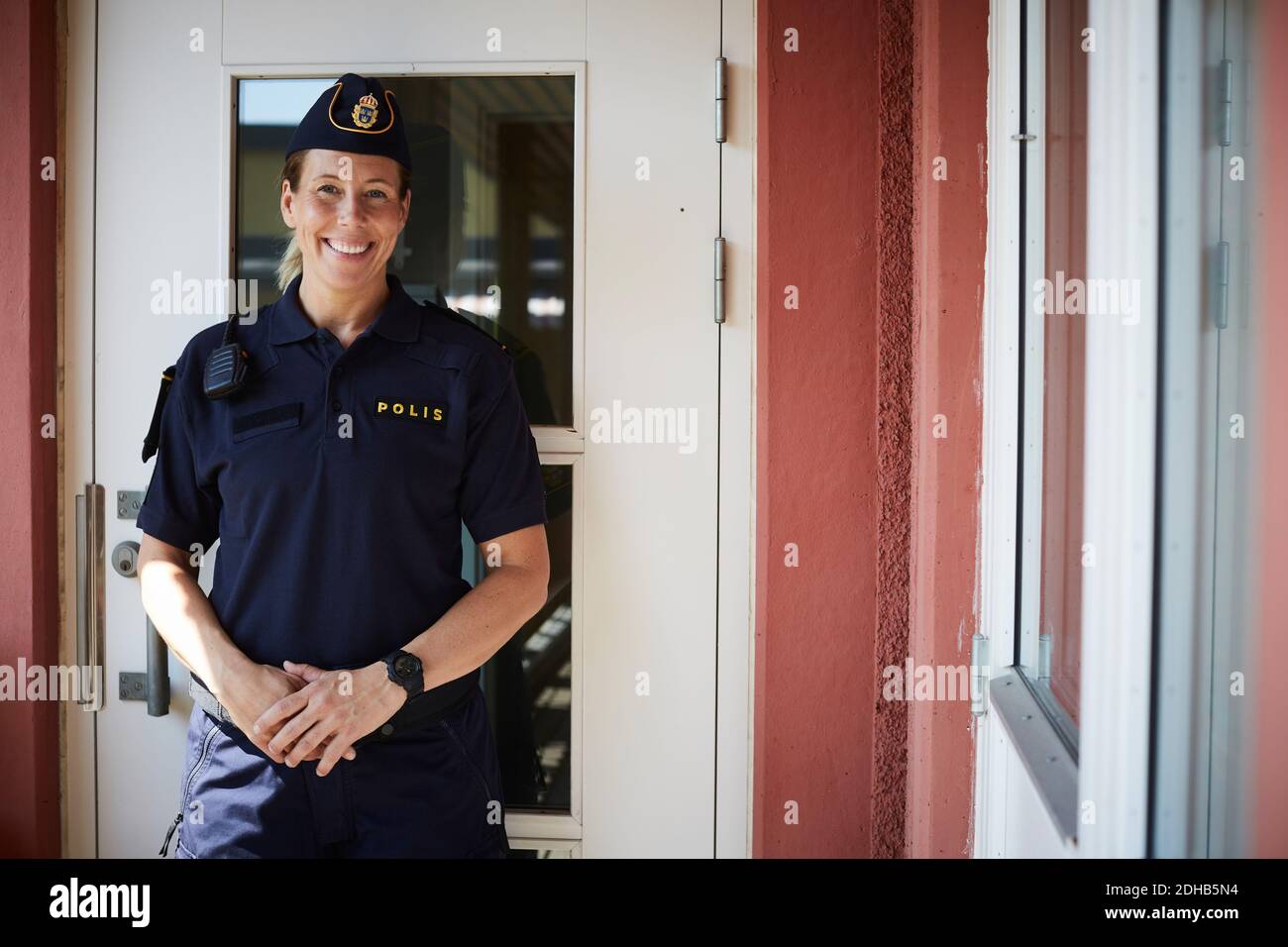 Portrait of smiling policewoman standing outside police station Stock ...