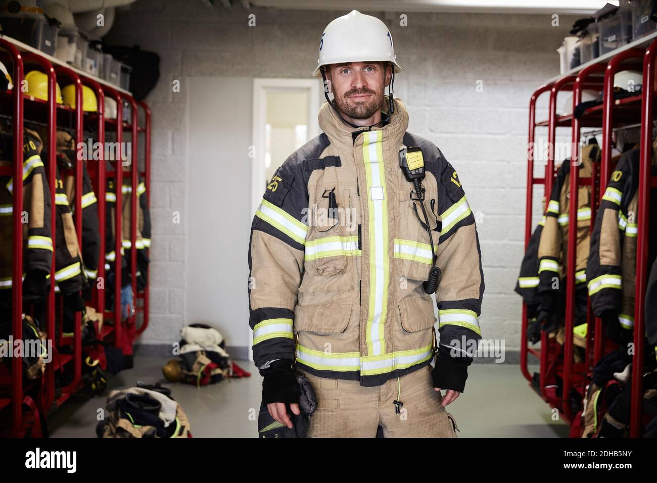 Portrait of confident male firefighter wearing protective uniform ...
