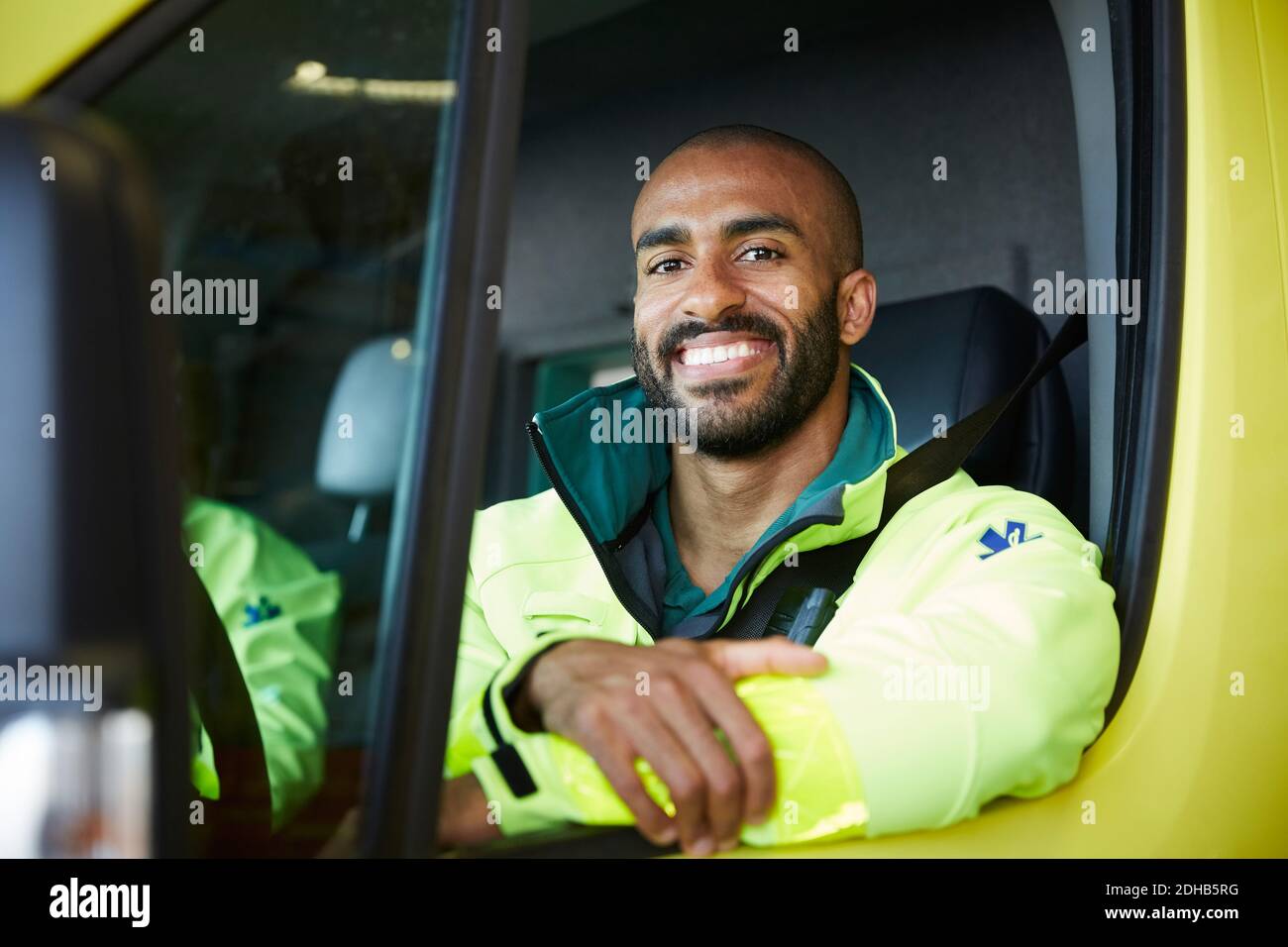 Portrait of smiling male paramedic in ambulance at parking lot Stock ...