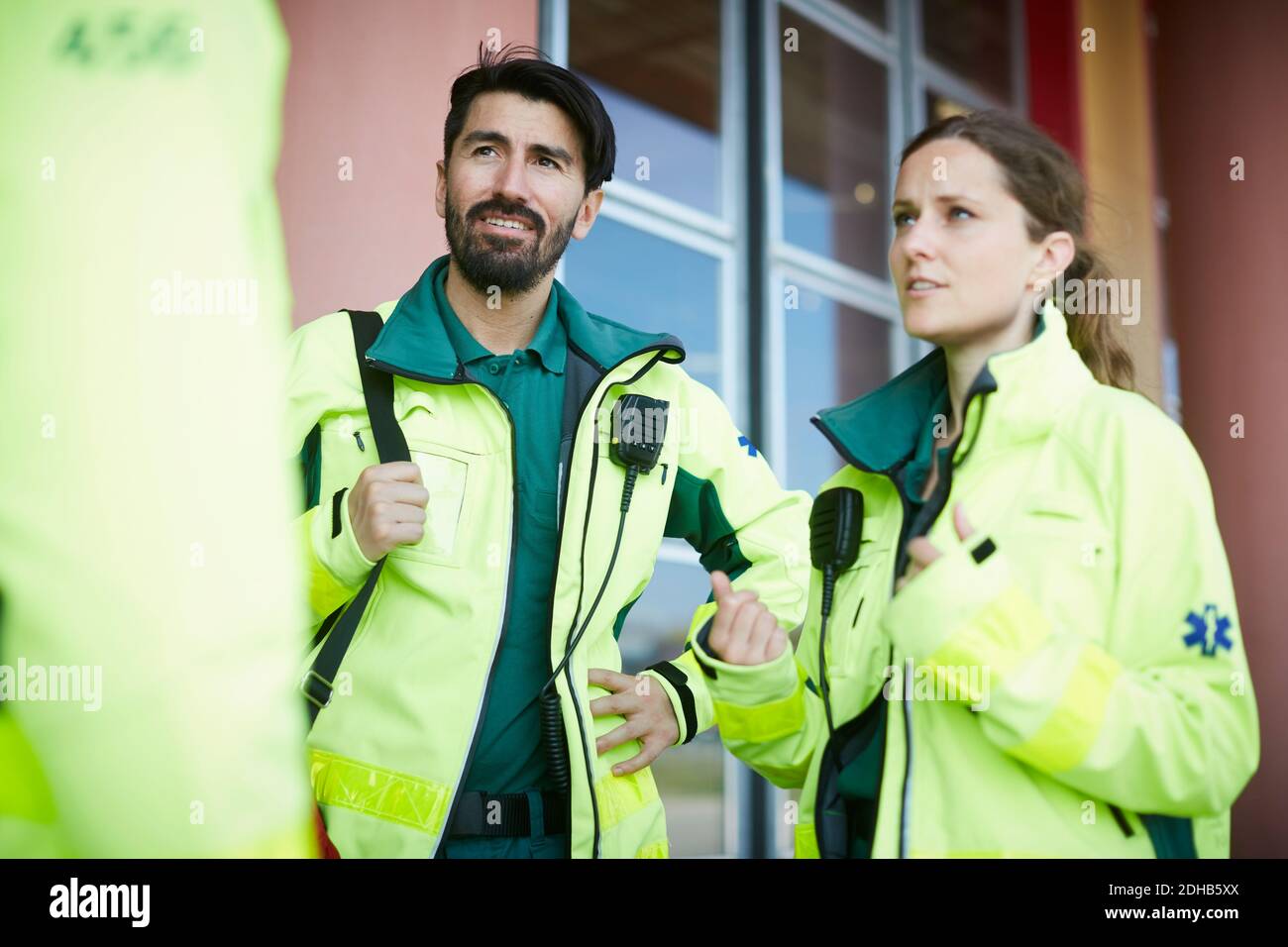 Male and female paramedics discussing while standing outside hospital ...
