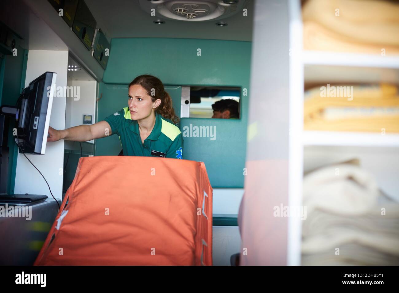 Female paramedic reading monitoring equipment screen in ambulance Stock ...
