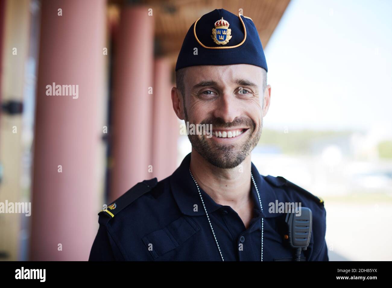 Portrait of smiling policeman standing outside police station Stock ...