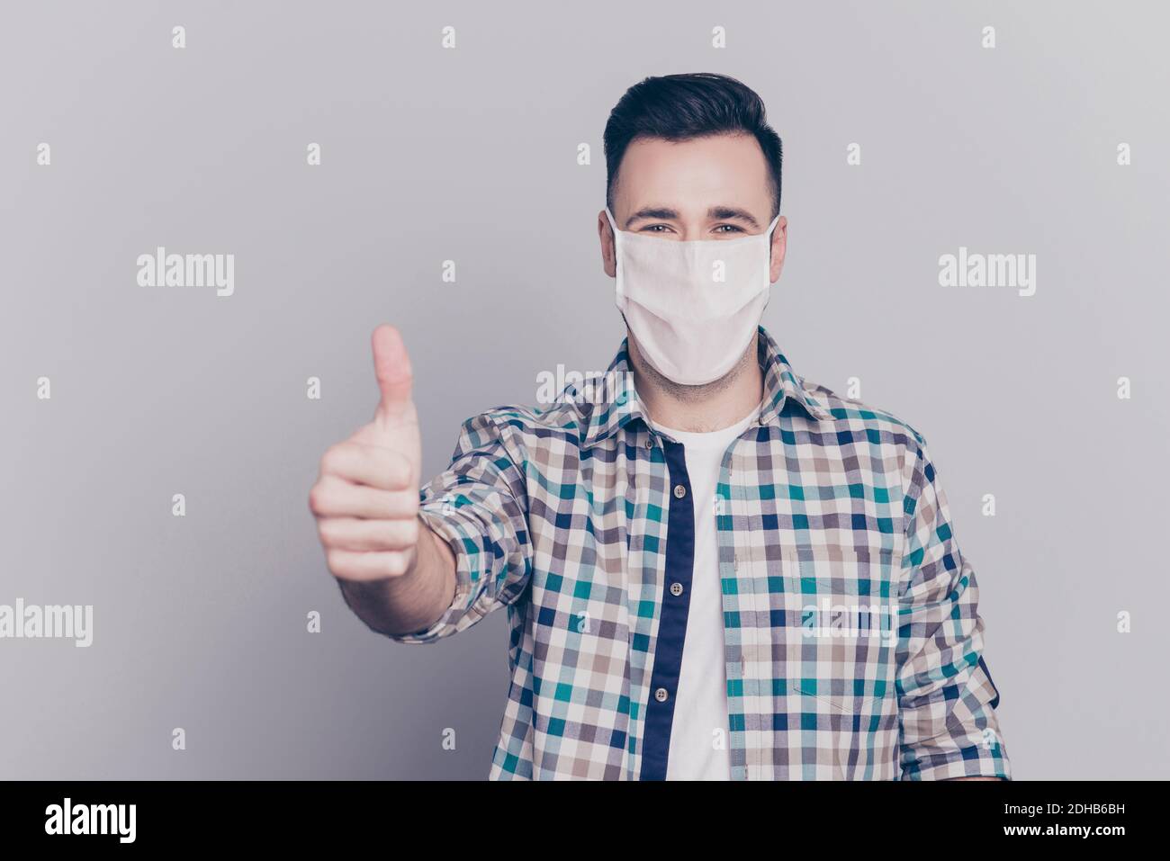 Portrait of attractive content guy wearing safety mask giving thumbup ...