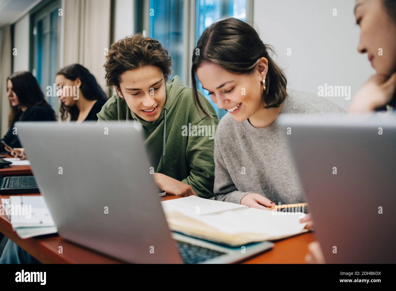 Smiling teenage students studying at desk in school Stock Photo - Alamy