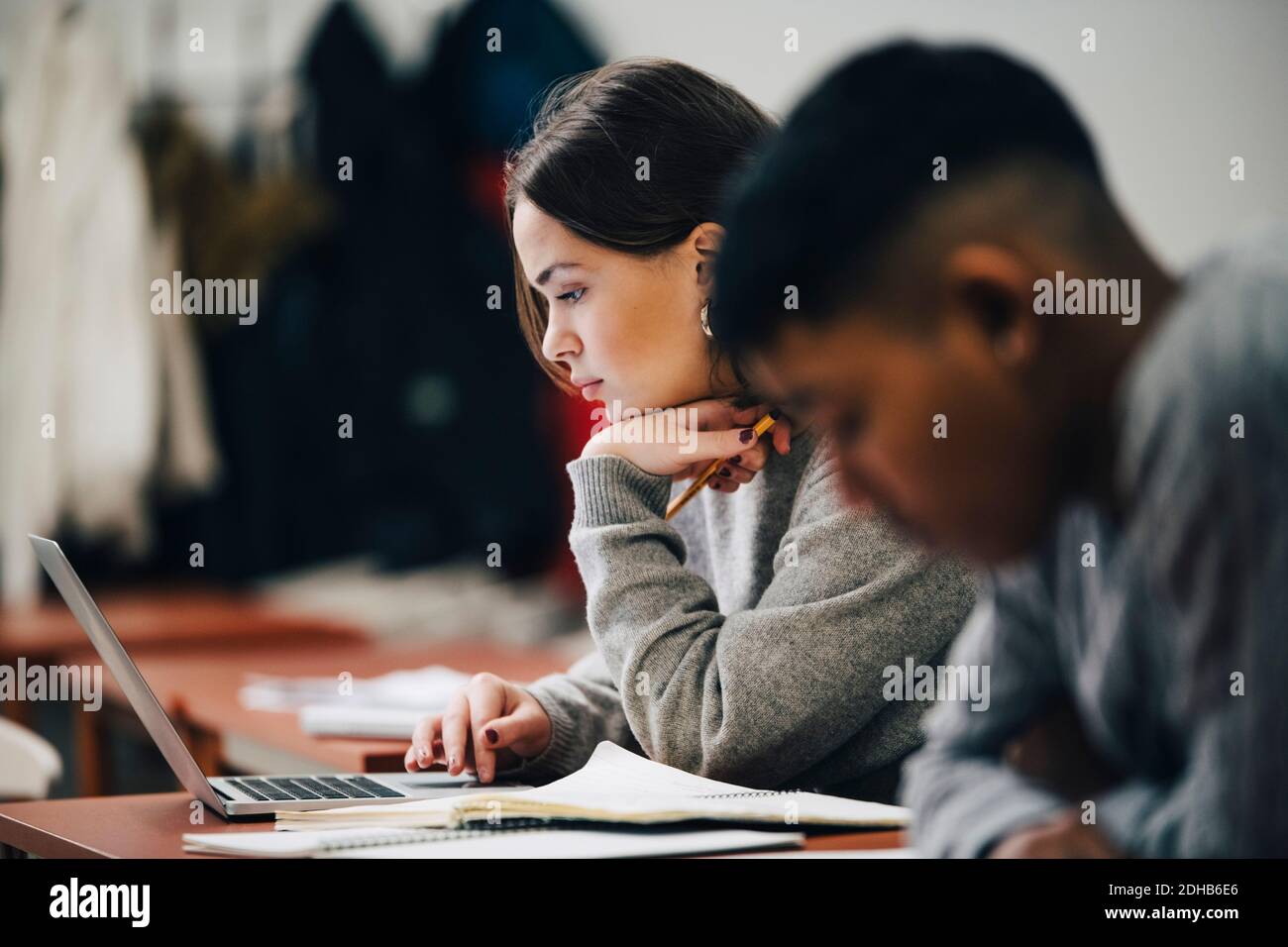 Teenage students studying at desk in classroom Stock Photo - Alamy