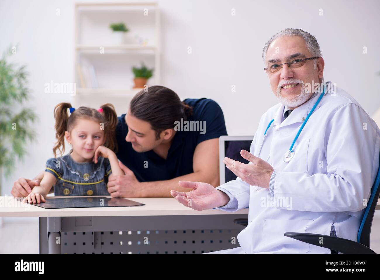 Young father and his daughter visiting old male doctor Stock Photo - Alamy