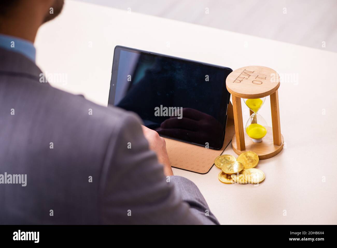 Young man earning money via Internet in time management concept Stock ...