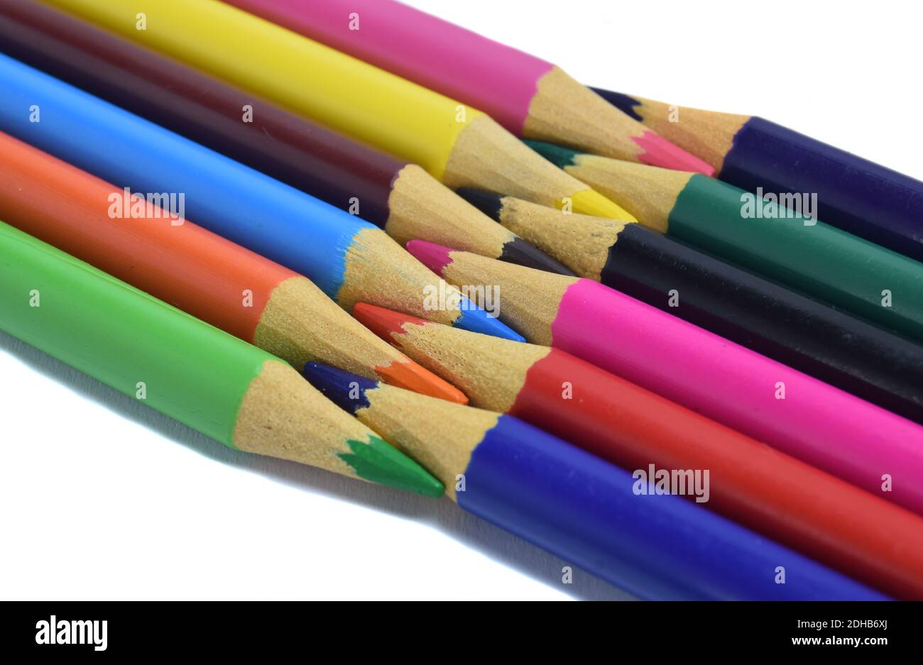 colored pencils arranged head to head isolated on a white background ...