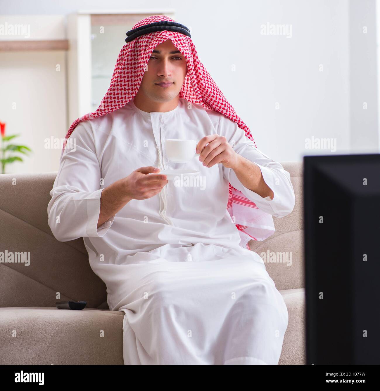 Arab businessman watching tv at home Stock Photo - Alamy