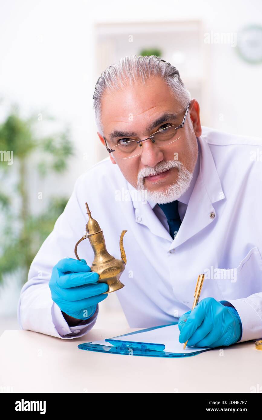 Old senior archaeologist working in the lab Stock Photo - Alamy