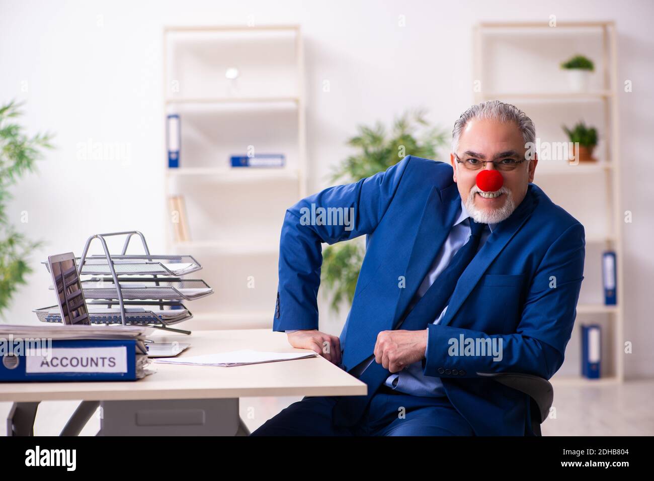 Old businessman clown working in the office Stock Photo - Alamy