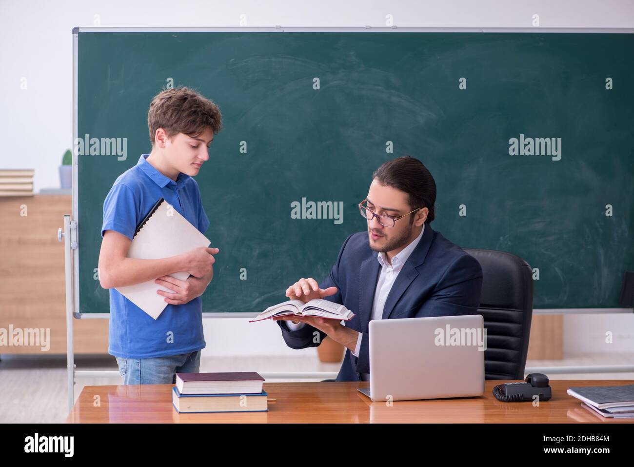 Young male teacher and schoolboy in the classroom Stock Photo - Alamy